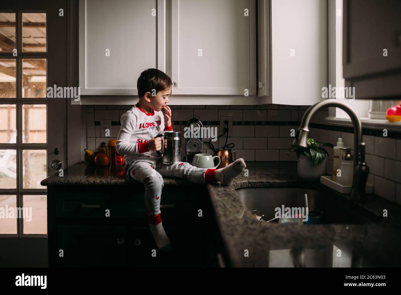 Boy sitting on counter hi-res stock photography and images - Alamy