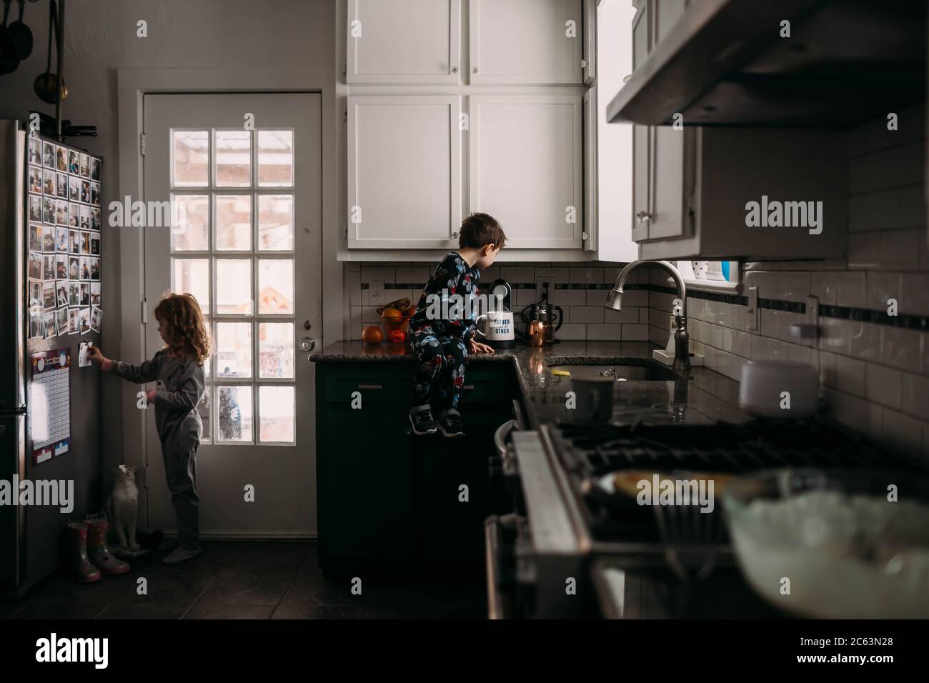Young boy and girl helping in kitchen during breakfast time Stock Photo ...