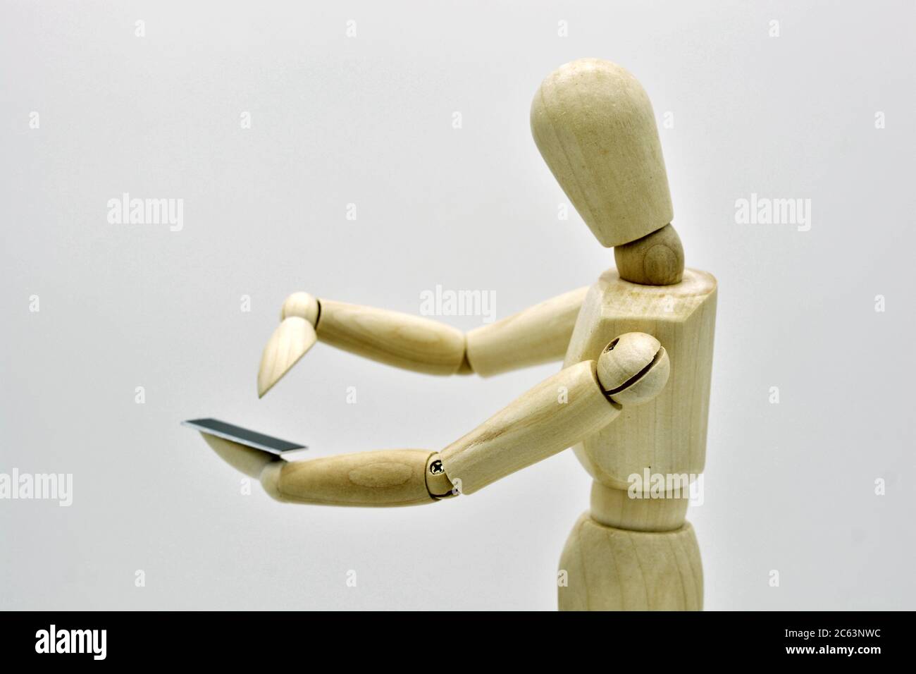 Wooden mannequin sitting, using a mobile phone Stock Photo - Alamy