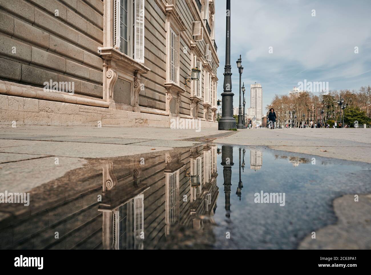 Ground level of stone sidewalk with aged building reflecting in water ...