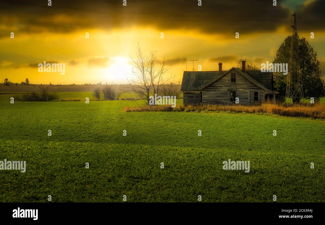 Old farmhouse in field at sunset with windmill Stock Photo - Alamy