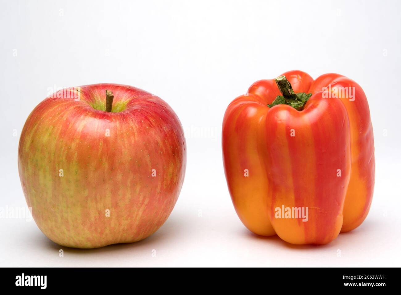 Variegated apple and pepper red and yellow on white background. Concept ...