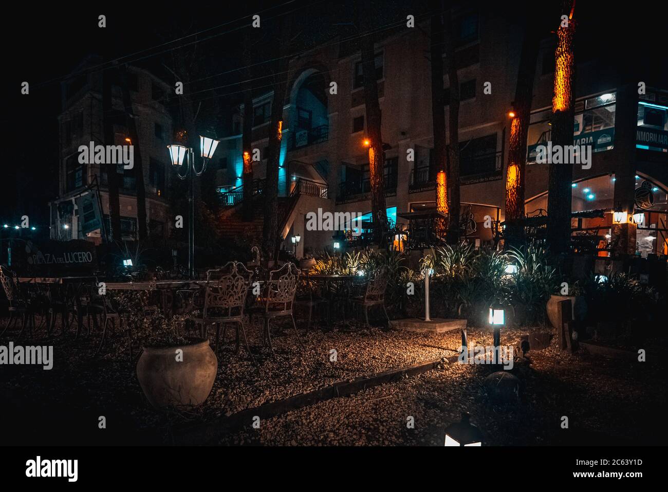 Night scene of an elegant outdoor bar illuminated by small lamps among ...
