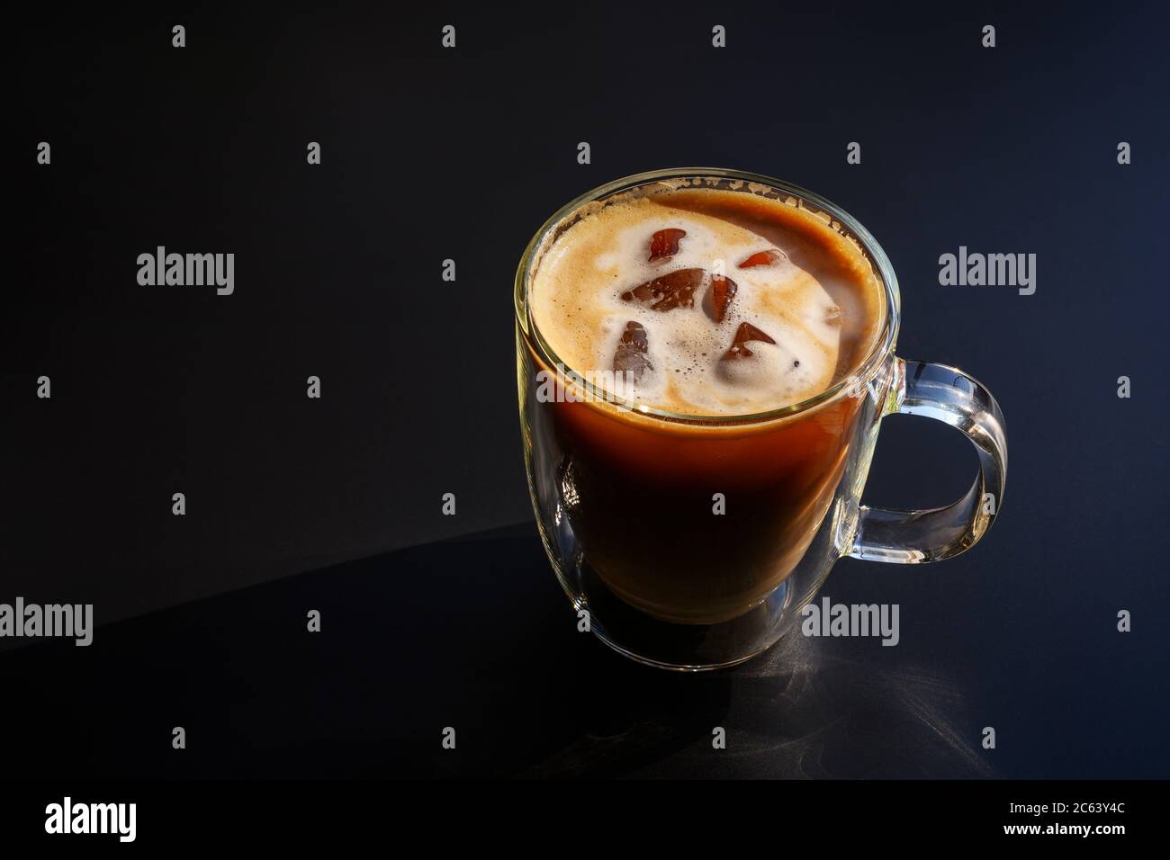 Top view, iced coffee with milk foam on top, double-layer glass on a ...