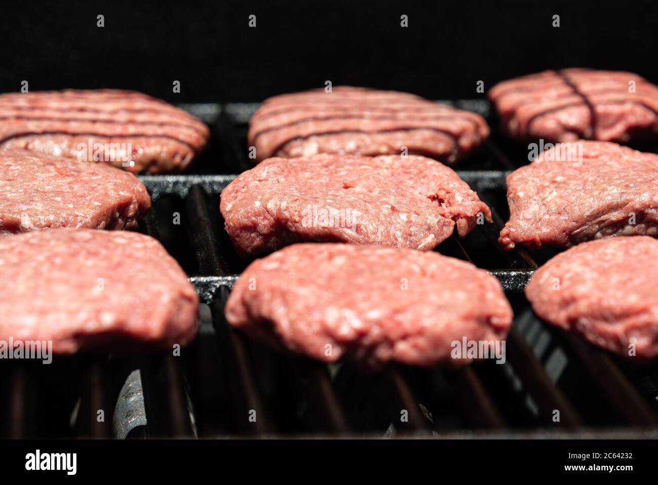 Raw meat patties on a grill Stock Photo - Alamy