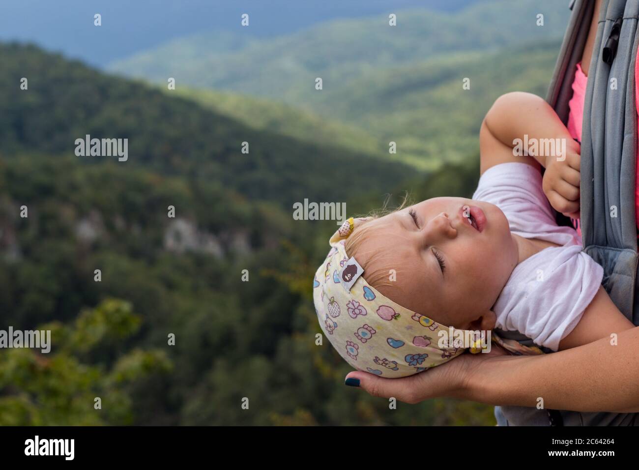 hiking with sleeping baby in backpack green hills behind Stock Photo ...