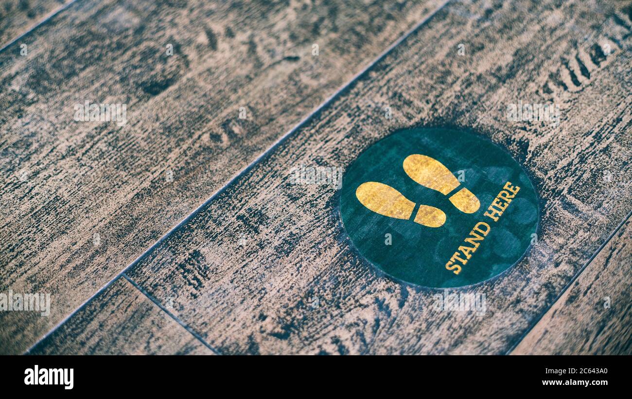 Stand here foot sign or symbol on the floor Stock Photo - Alamy