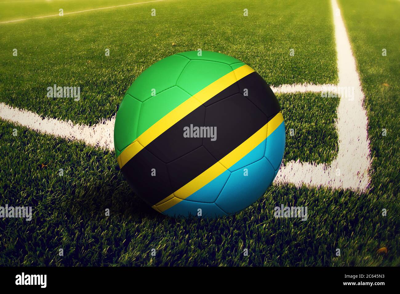 Tanzania flag on ball at corner kick position, soccer field background ...