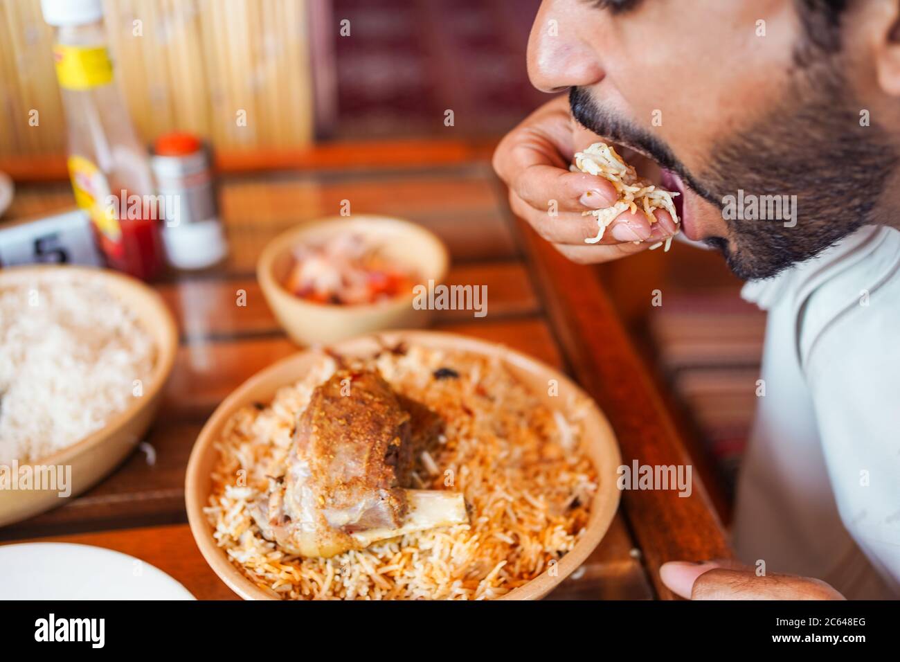 Nizwa / Oman - February 15, 2020: Man eating using hand a traditional ...