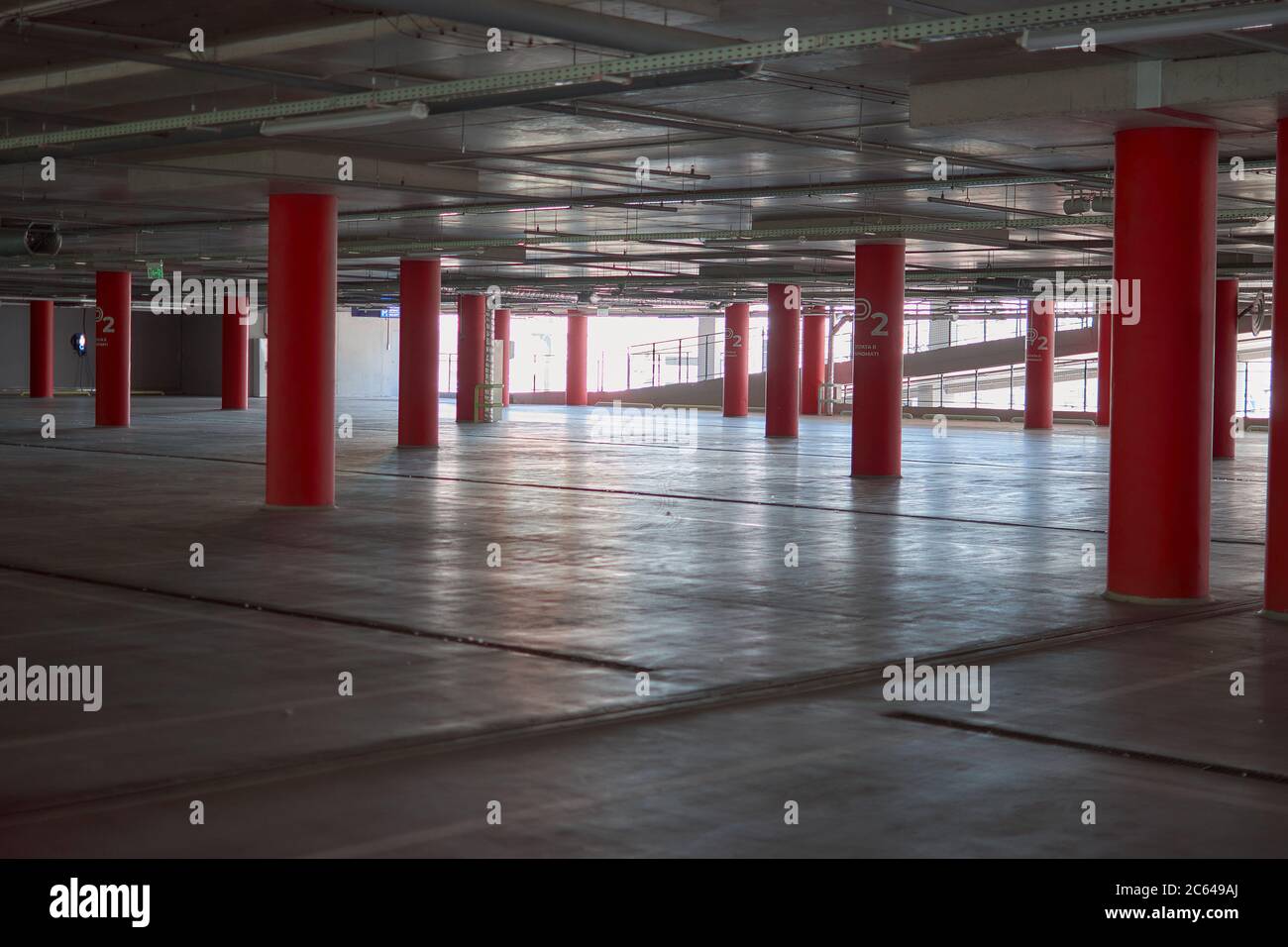 Underground empty parking garage with overhead lights and an exit sign ...