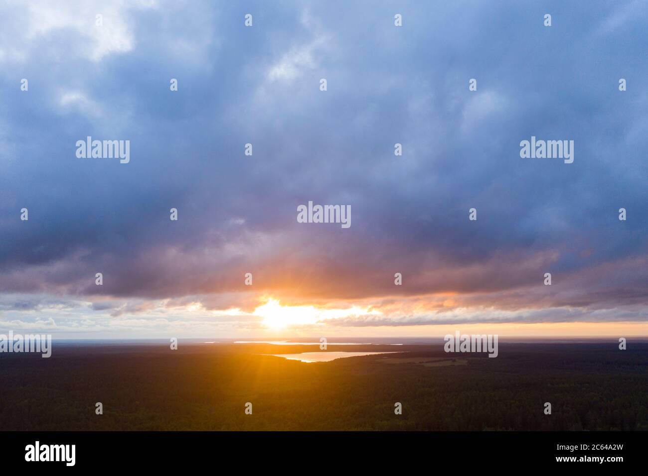 Aerial view sunset over the forest and lake. Top view. View from drone ...
