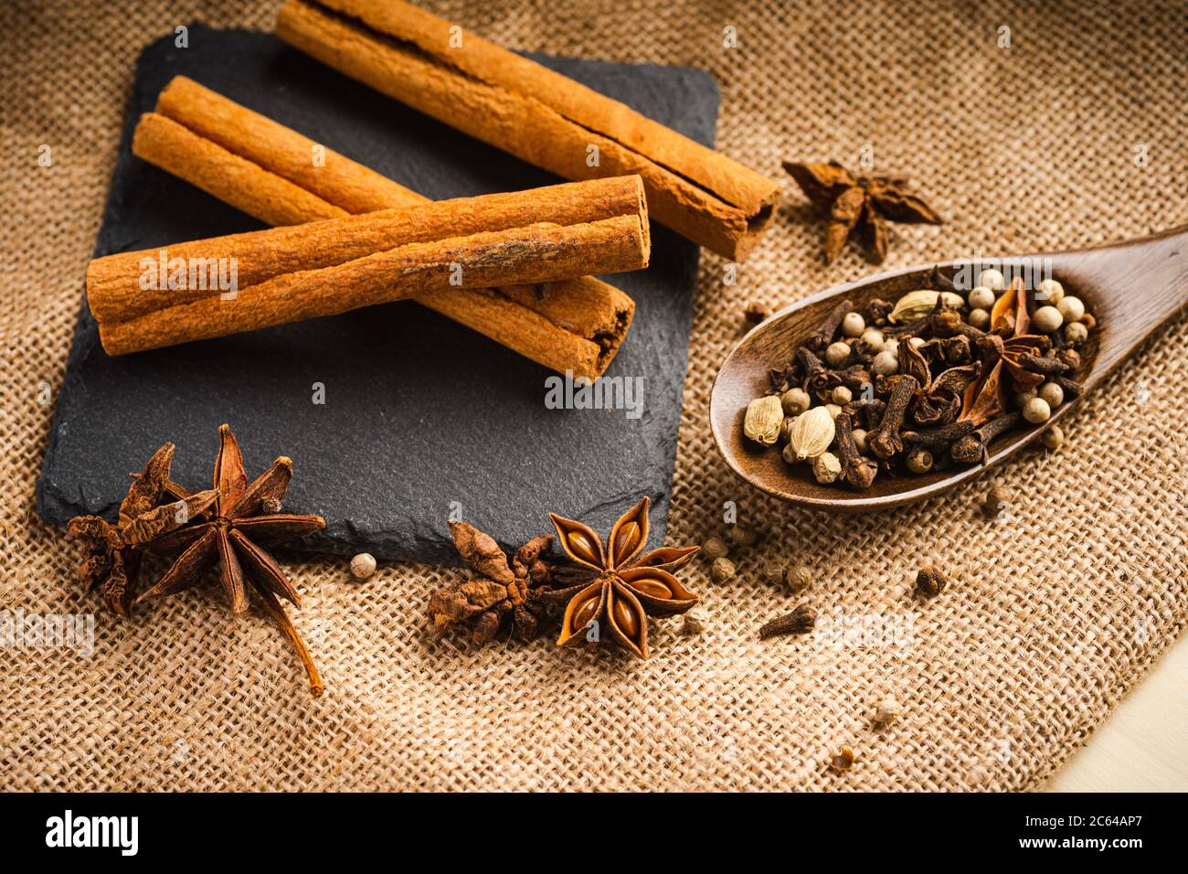 Various spices on a wooden spoon on top of a rag Stock Photo - Alamy