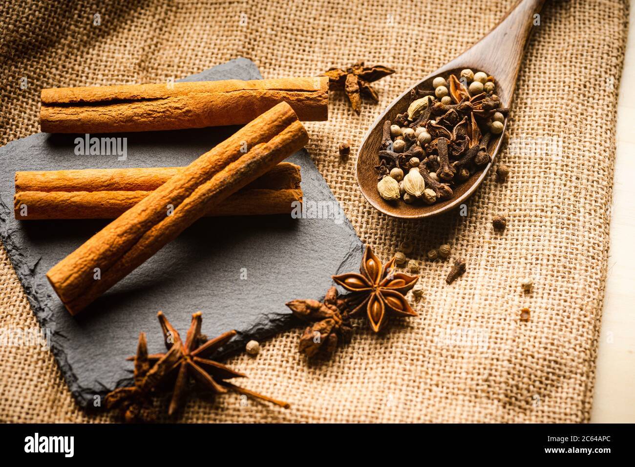 Various spices on a wooden spoon on top of a rag Stock Photo - Alamy