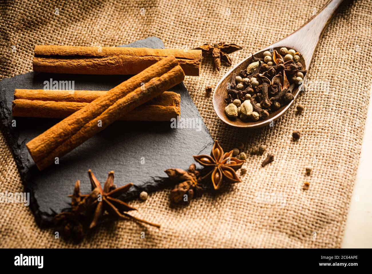 Various spices on a wooden spoon on top of a rag Stock Photo - Alamy