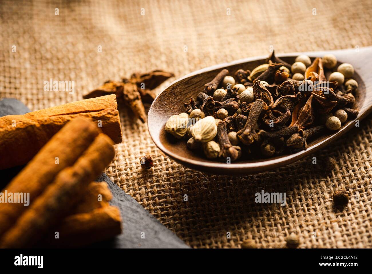 Various spices on a wooden spoon on top of a rag Stock Photo - Alamy