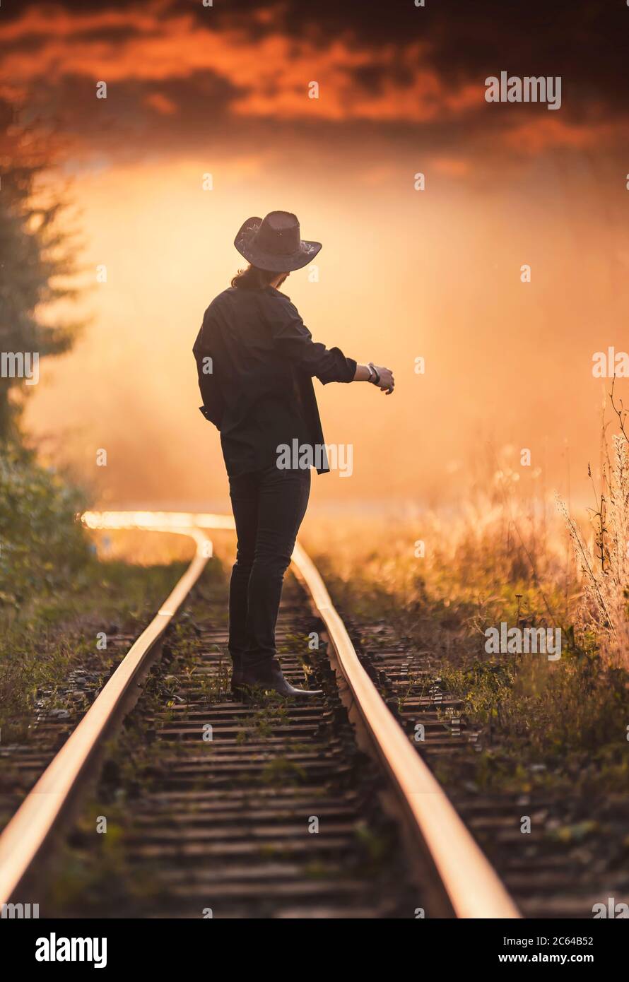 Cowboy walking on a railway line Stock Photo - Alamy