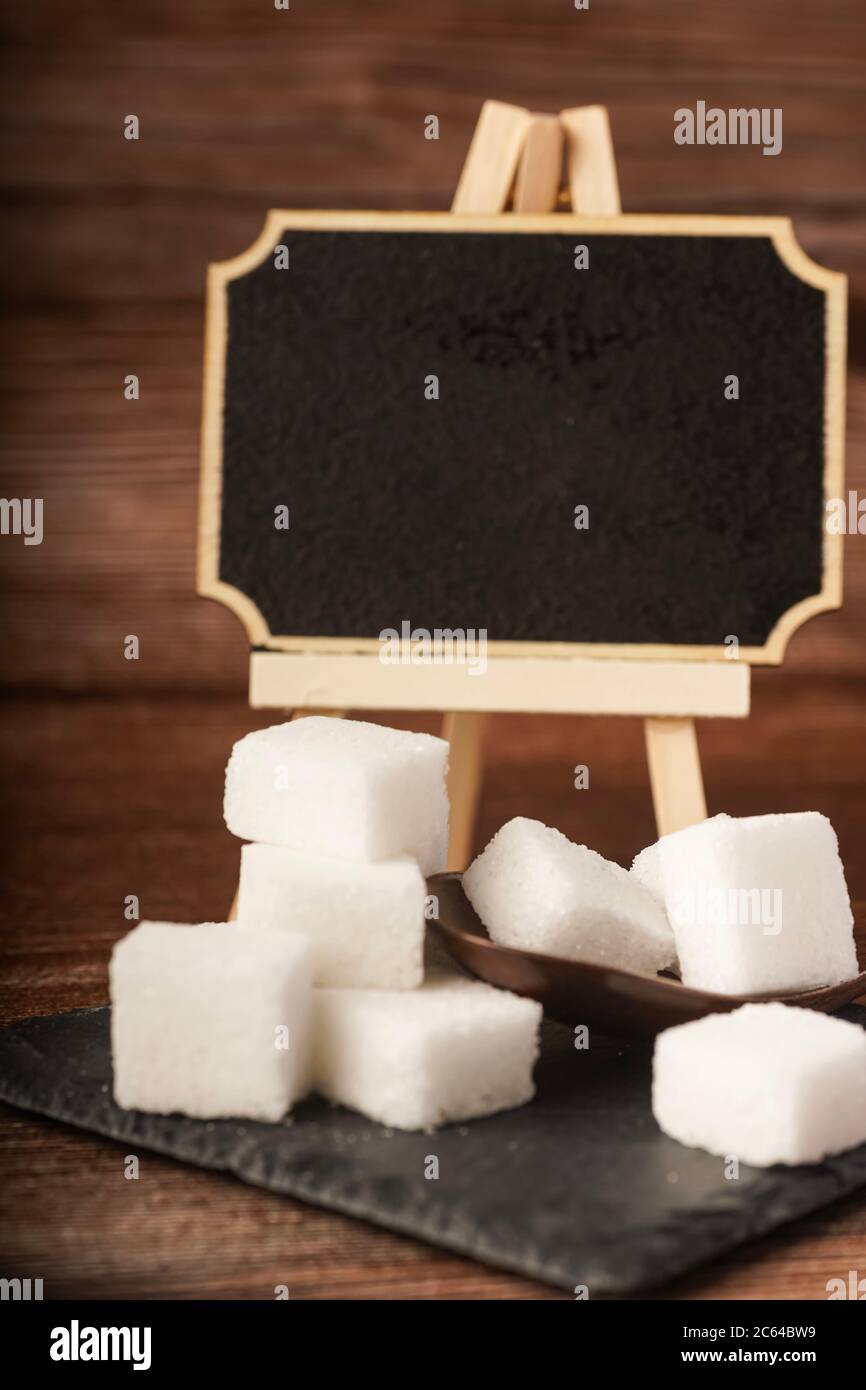 Sugar cubes with wooden spoon. Unhealthy eating concept Stock Photo - Alamy
