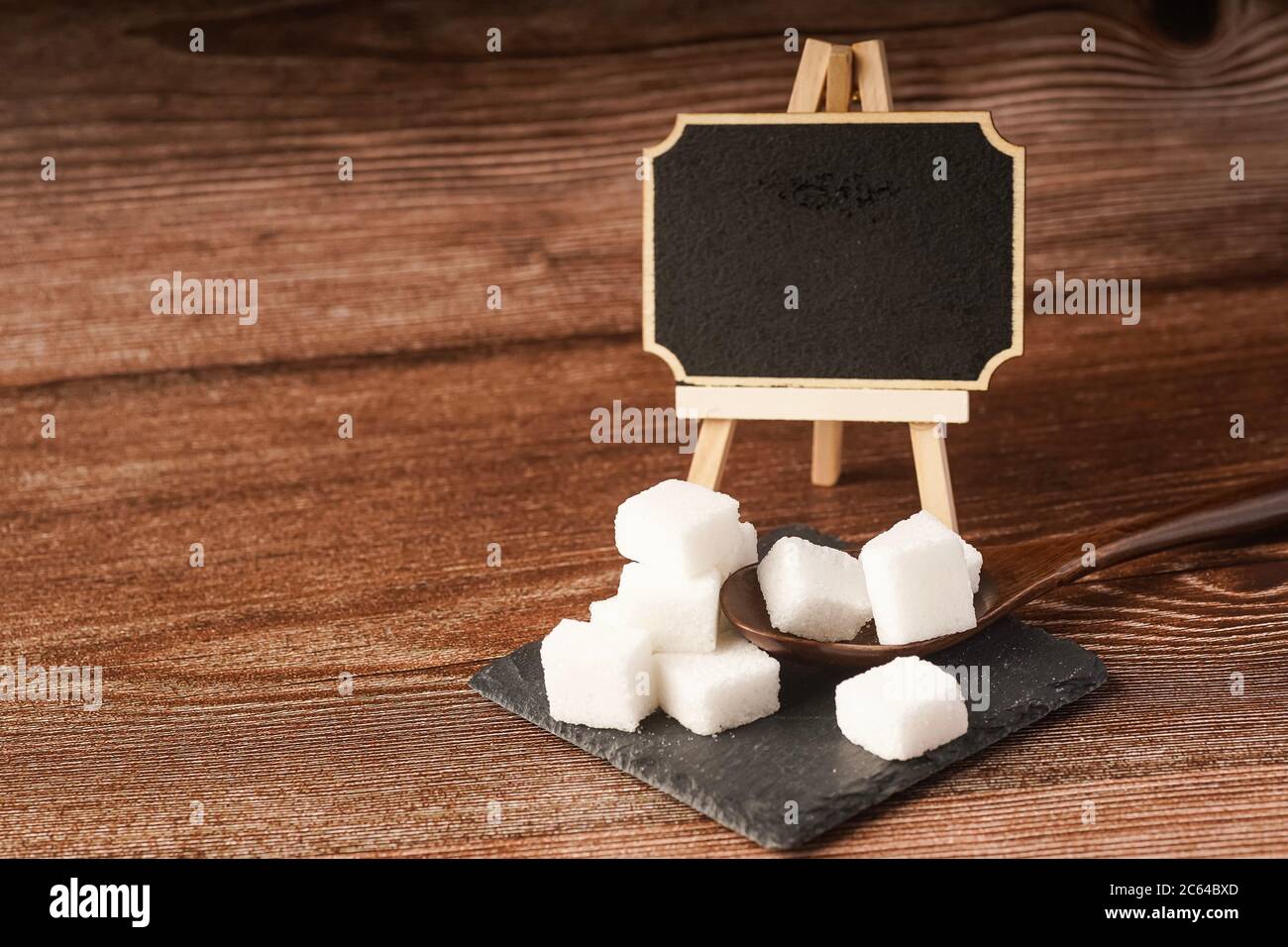 Sugar cubes with wooden spoon. Unhealthy eating concept Stock Photo - Alamy
