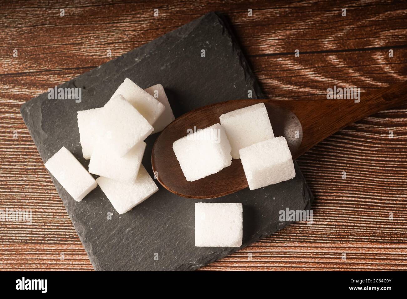 Sugar cubes with wooden spoon. Unhealthy eating concept Stock Photo - Alamy