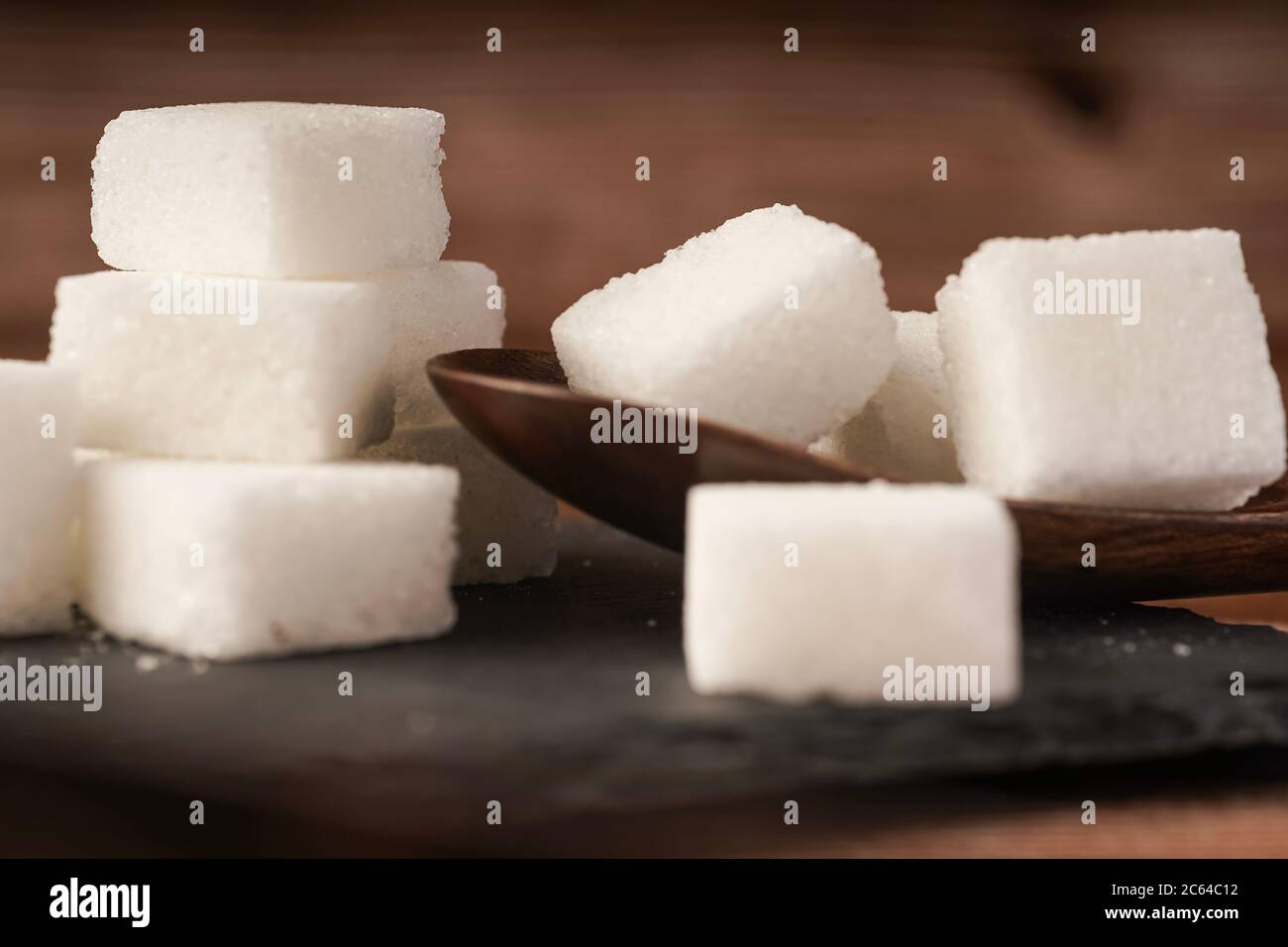 Sugar cubes with wooden spoon. Unhealthy eating concept Stock Photo - Alamy