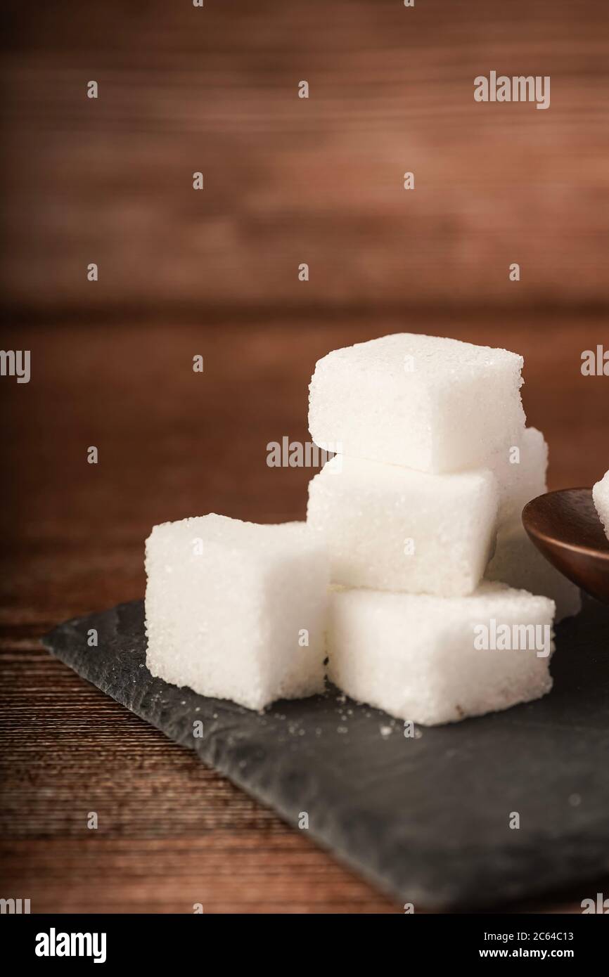 Sugar cubes with wooden spoon. Unhealthy eating concept Stock Photo - Alamy