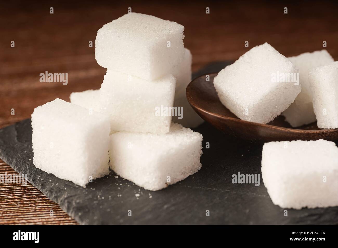 Sugar cubes with wooden spoon. Unhealthy eating concept Stock Photo - Alamy