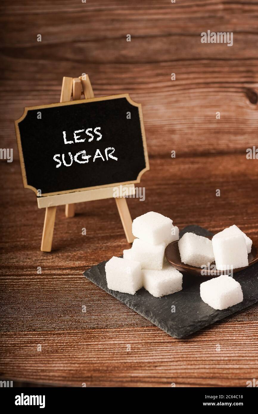 Sugar cubes with wooden spoon. Unhealthy eating concept Stock Photo - Alamy
