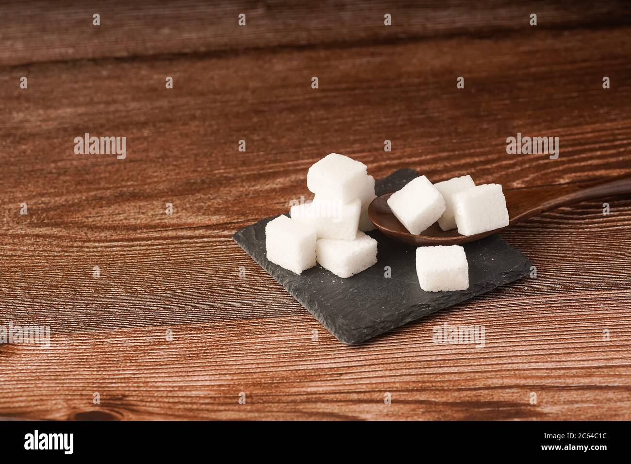 Sugar cubes with wooden spoon. Unhealthy eating concept Stock Photo - Alamy