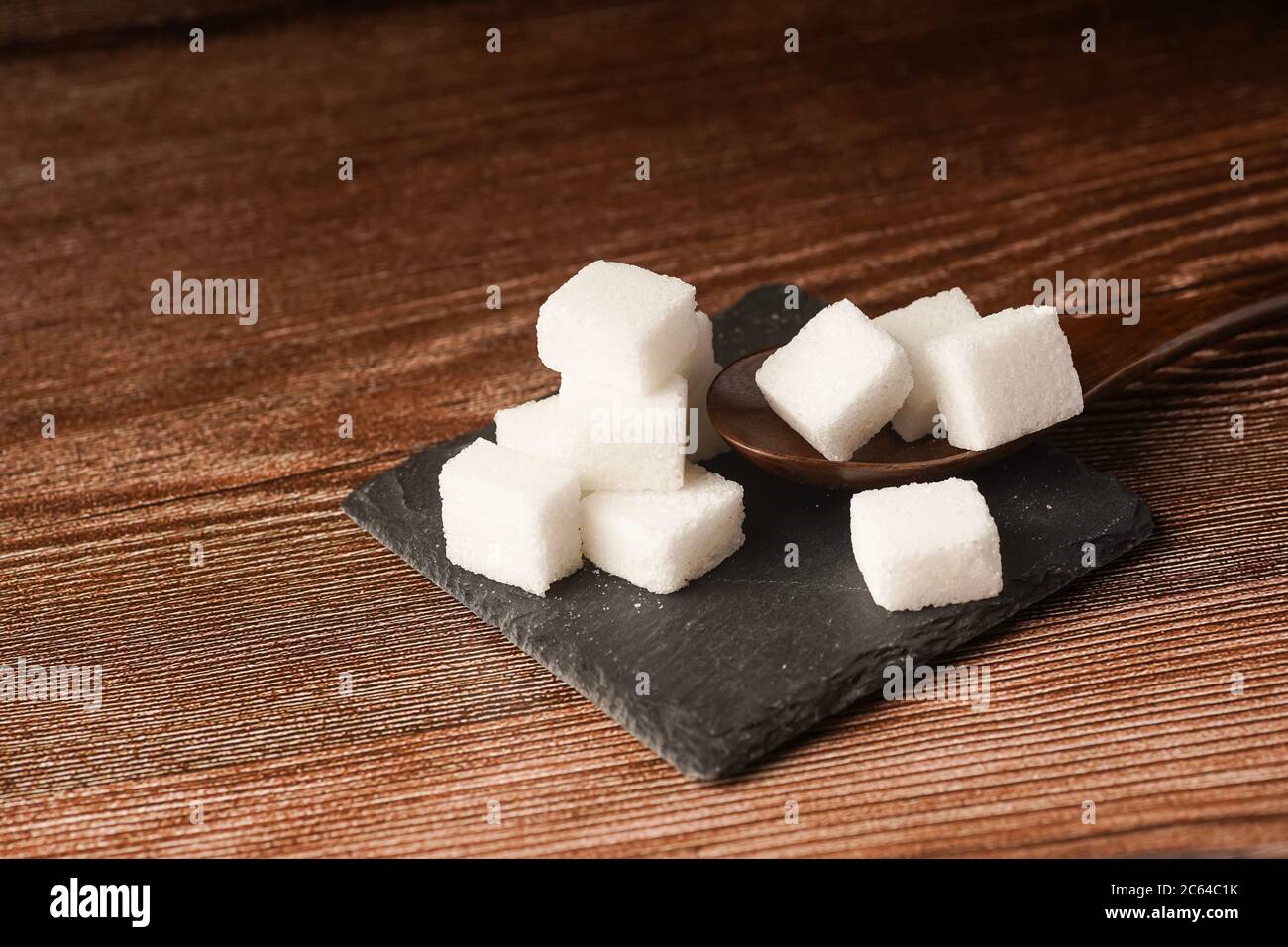 Sugar cubes with wooden spoon. Unhealthy eating concept Stock Photo - Alamy