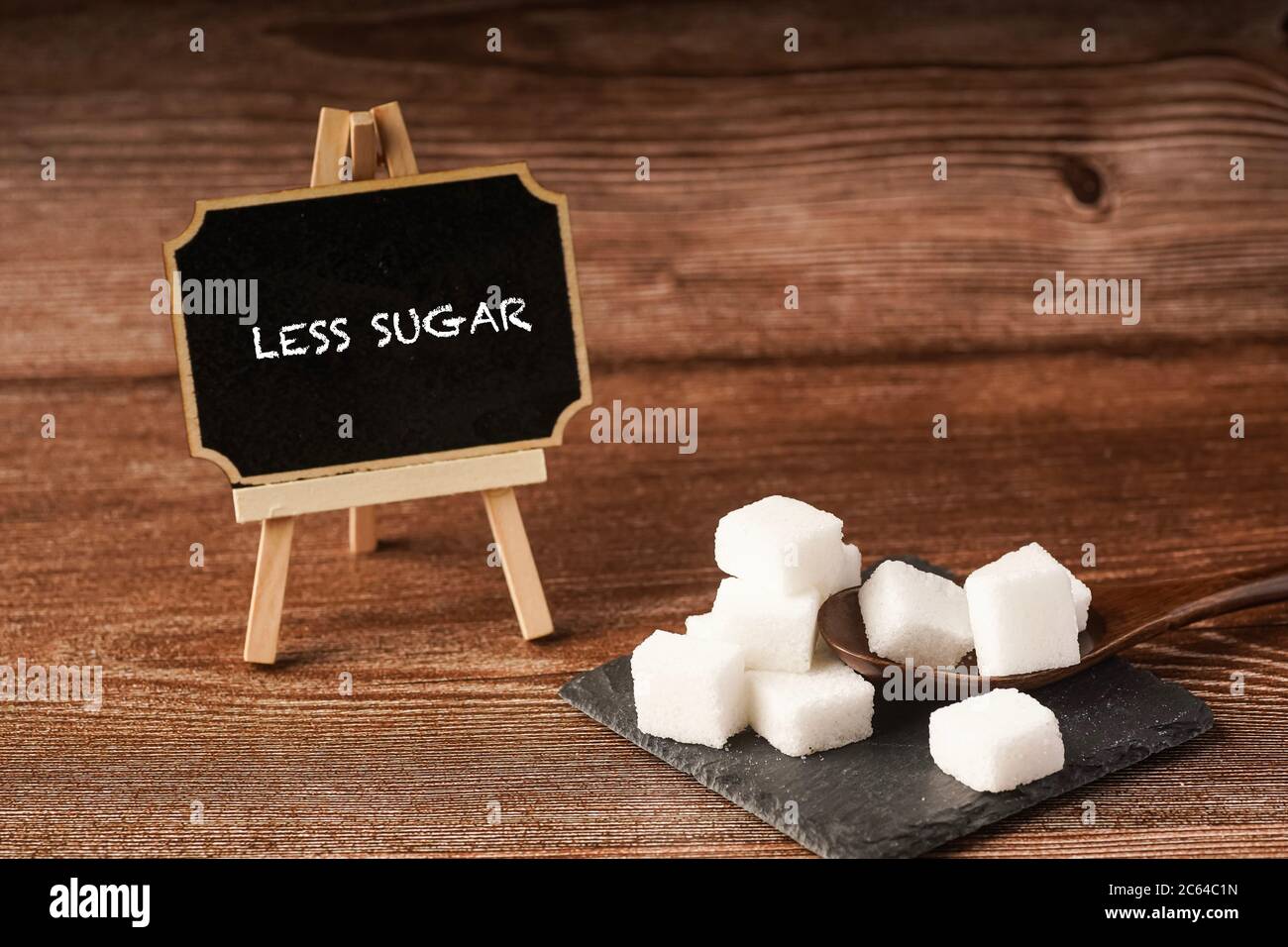 Sugar cubes with wooden spoon. Unhealthy eating concept Stock Photo - Alamy
