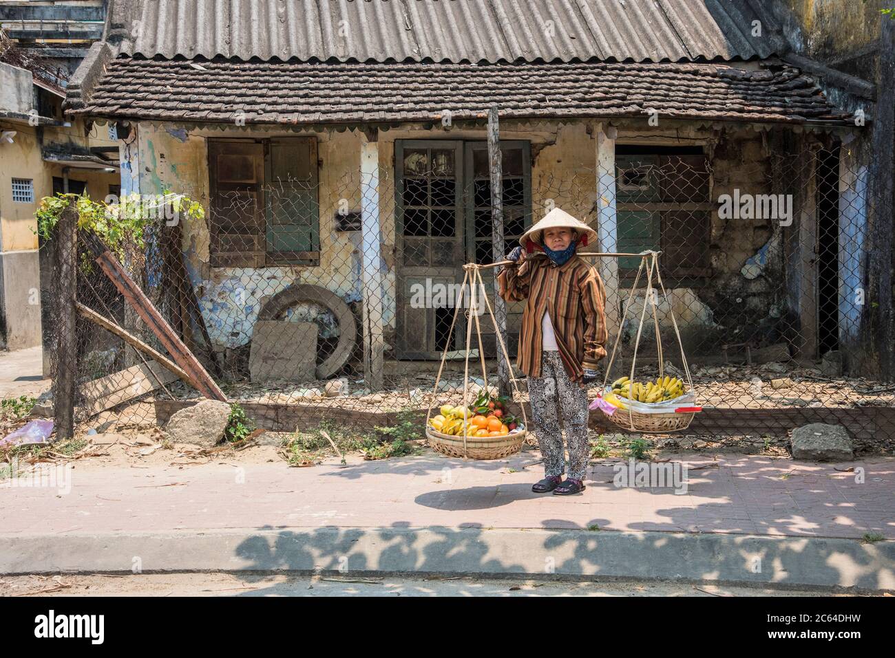 Traditional Vietnamese lady carrying fruit using traditional shoulder ...