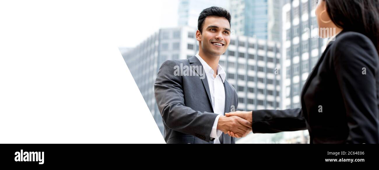 Smiling handsome young Indian businessman making handshake with ...