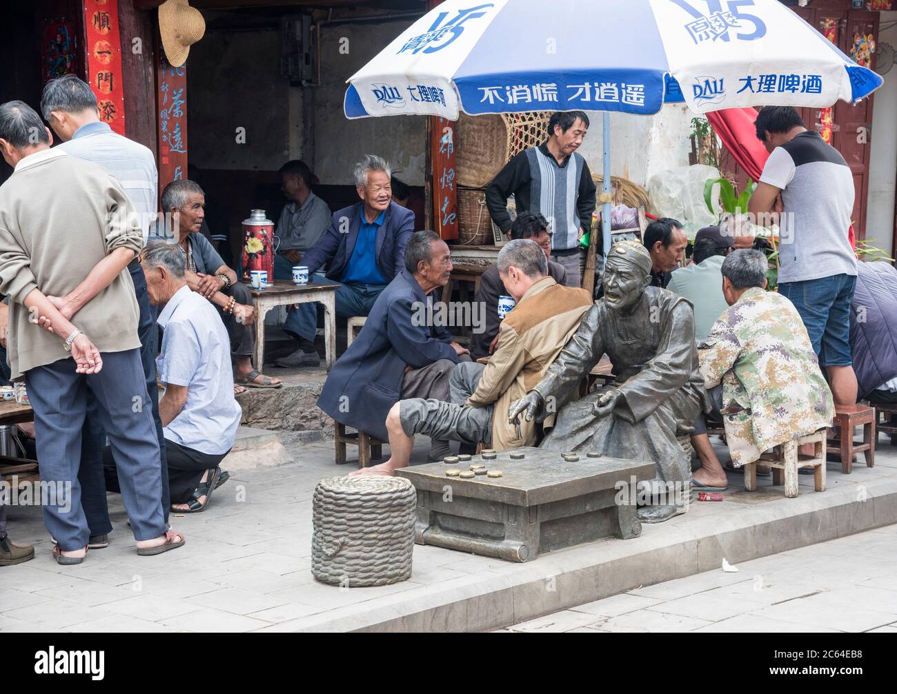 A group of Chinese men playing a traditional mahjong game outdoors in ...