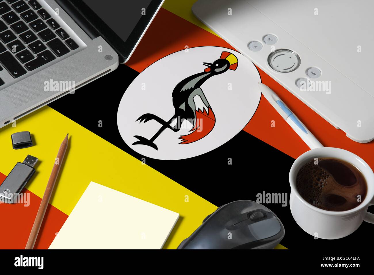 Uganda national flag on top view work space of creative designer with ...