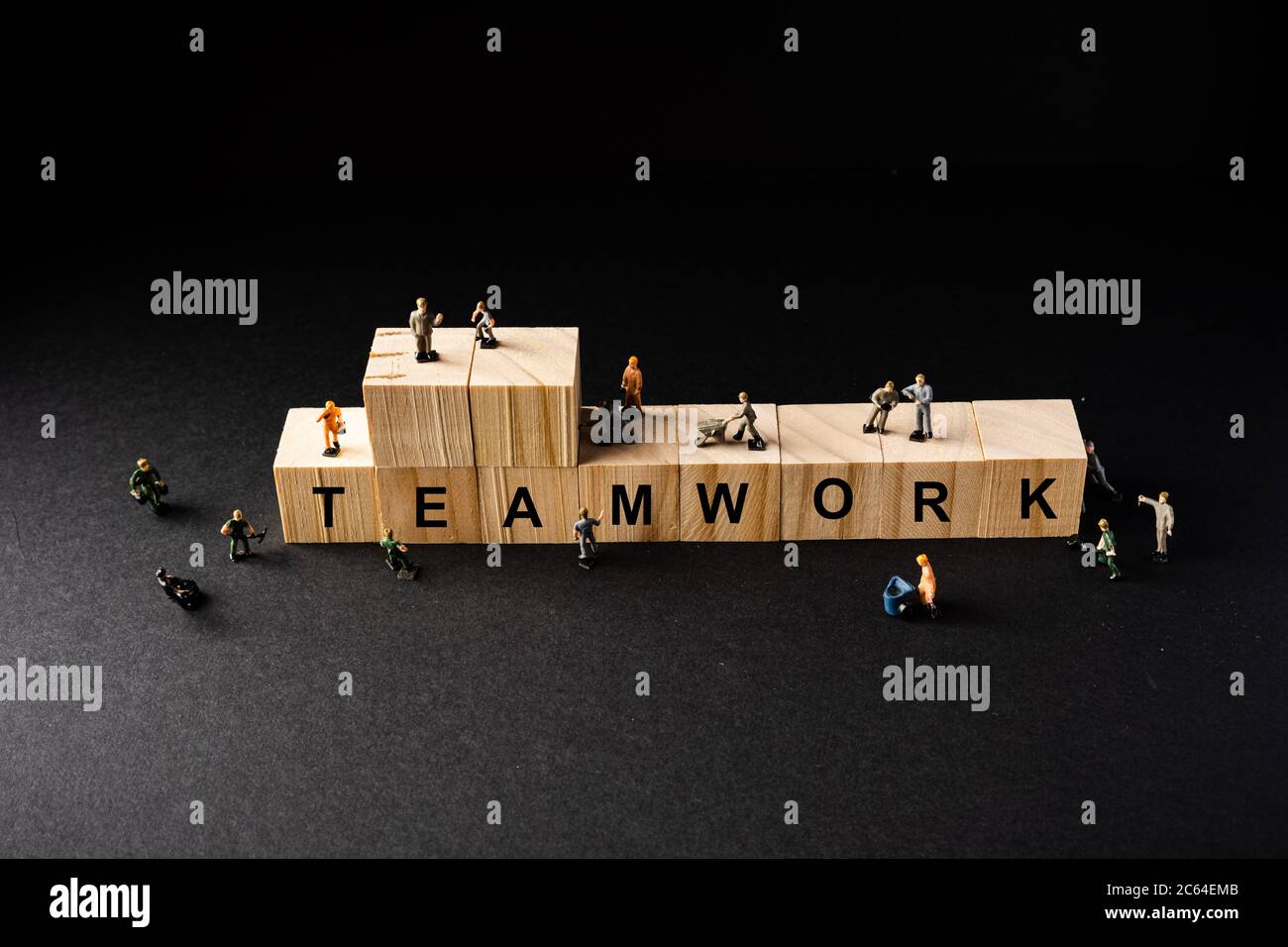 Teamwork concept. Miniature builders figure with wooden blocks with ...