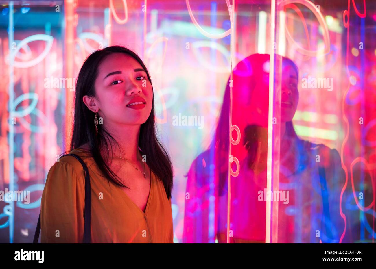 Asian woman portrait lit up by neon illuminated mirrors at night Stock ...