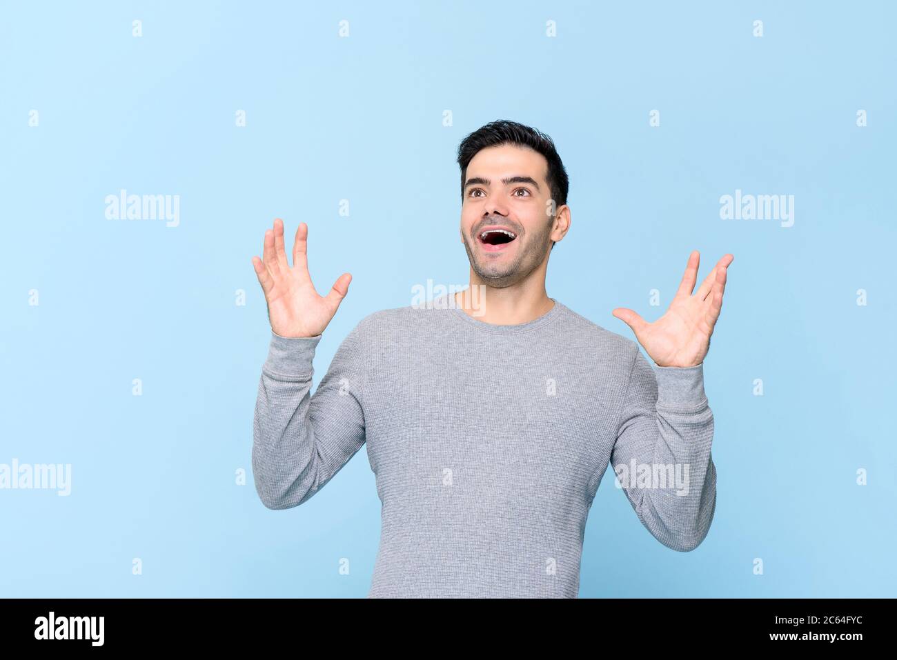 Surprised Caucasian man gasping and raising hands up isolated on light ...