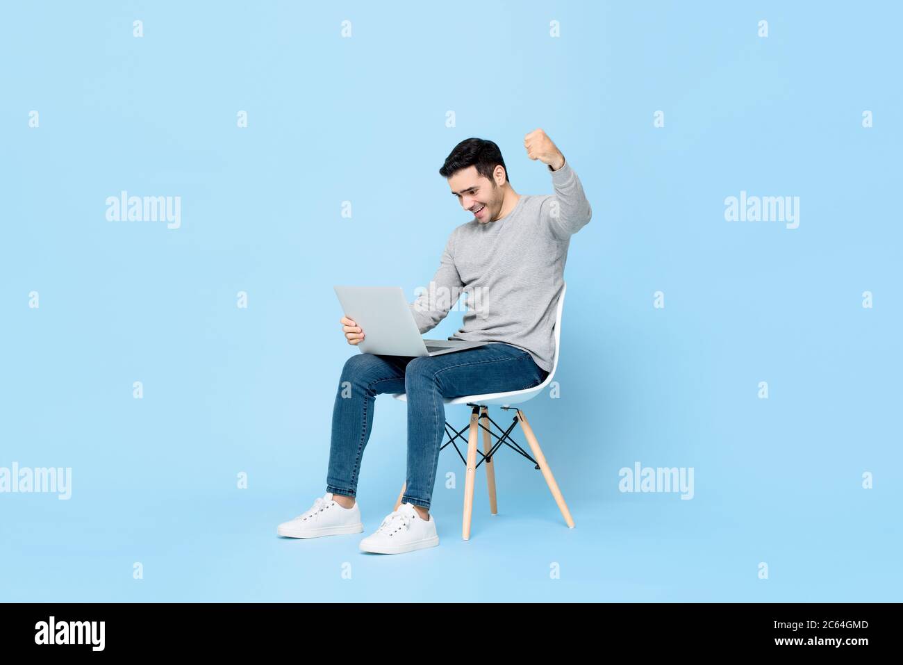 Surpried young Caucasian man looking at laptop computer and raising his ...