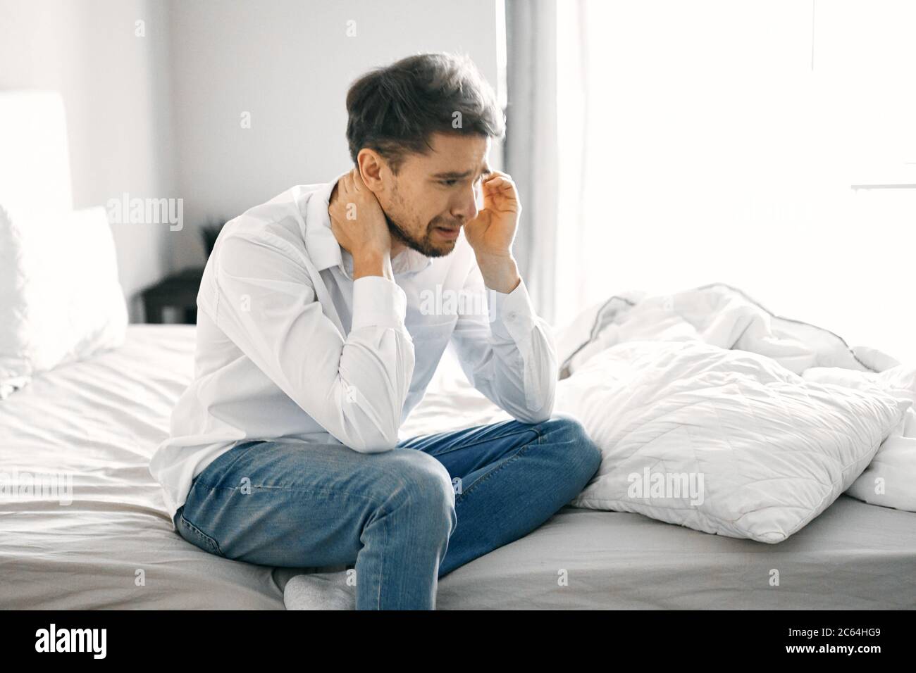 A lonely man cries on a bed near window Stock Photo - Alamy
