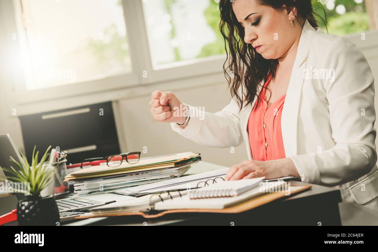 Angry businesswoman hitting her desk with her clenched fist Stock Photo ...