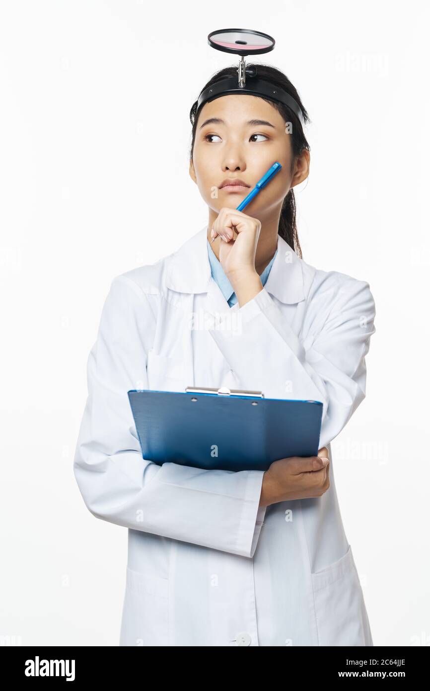 Female doctor with a medical tool on her head and documents Stock Photo ...