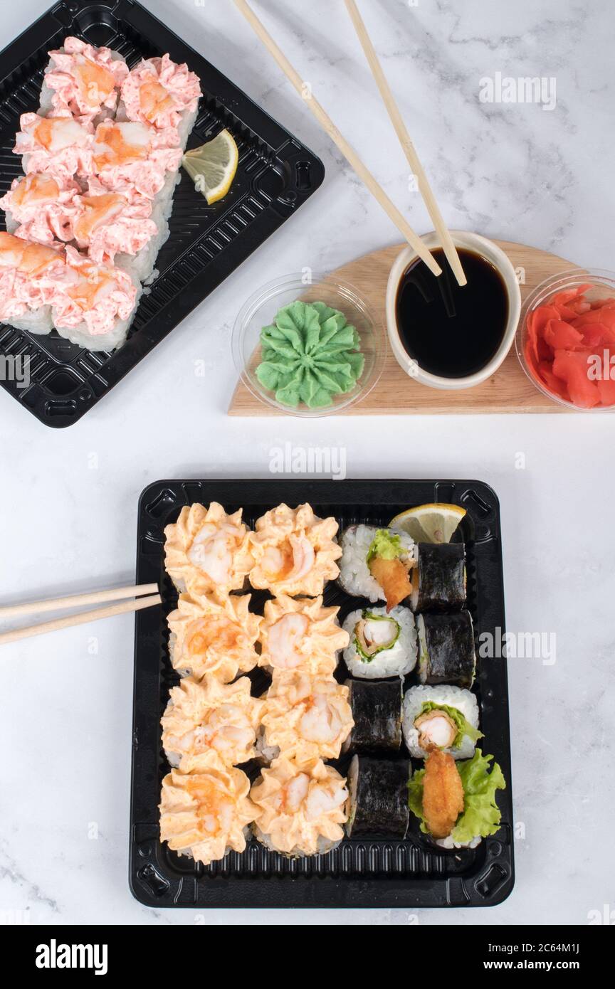 Sushi rolls set served on dark wooden board with wasabi, soy sauce and ...