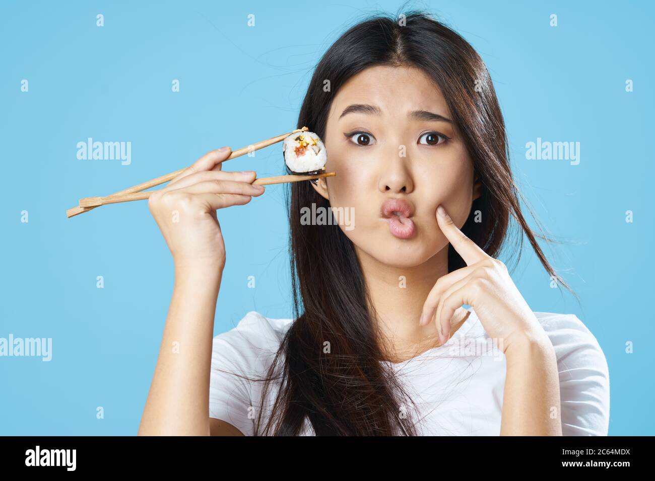 Girl with wooden chopsticks keeps drying and looks at the camera Stock ...
