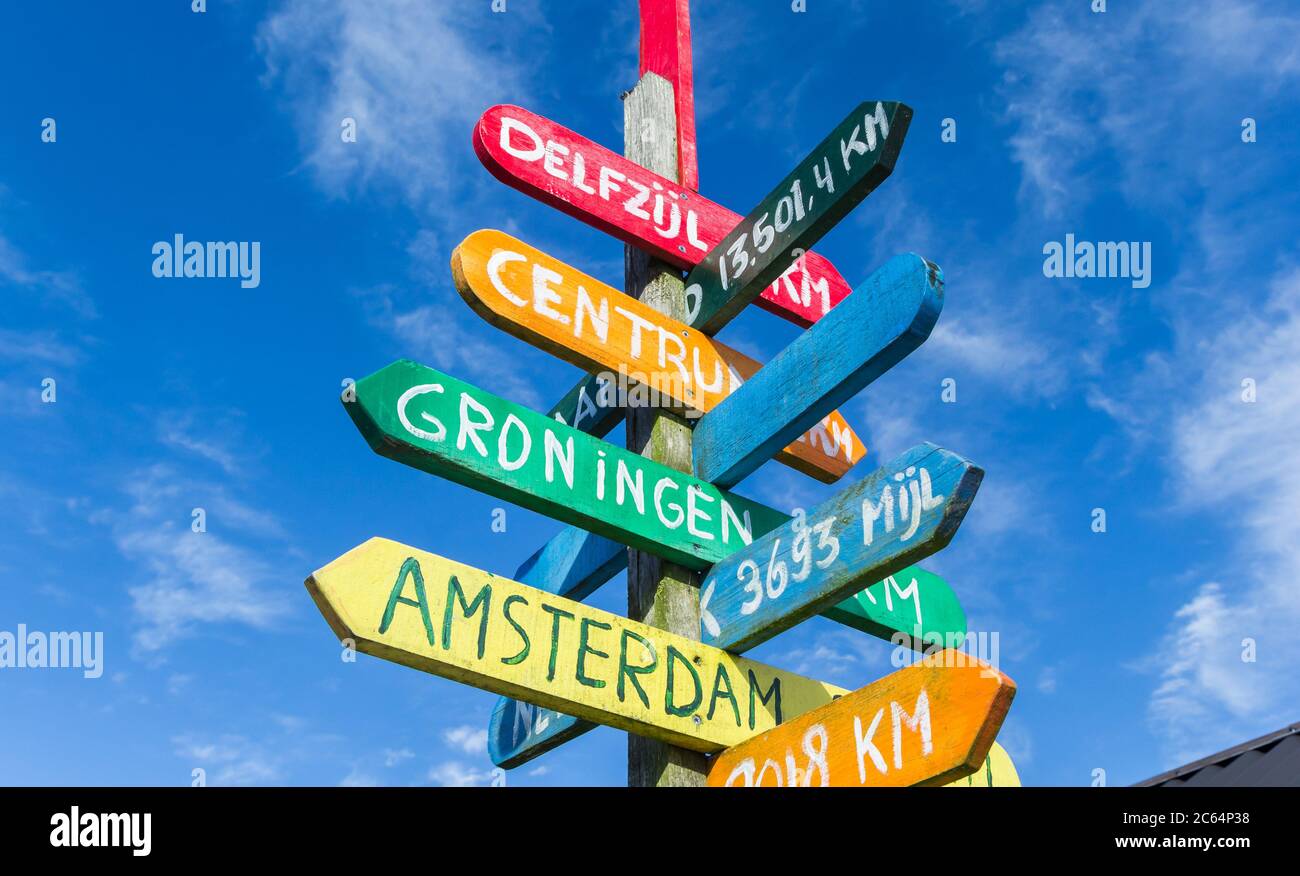 Colorful signpost pointing to various cities in Appingedam, Netherlands ...