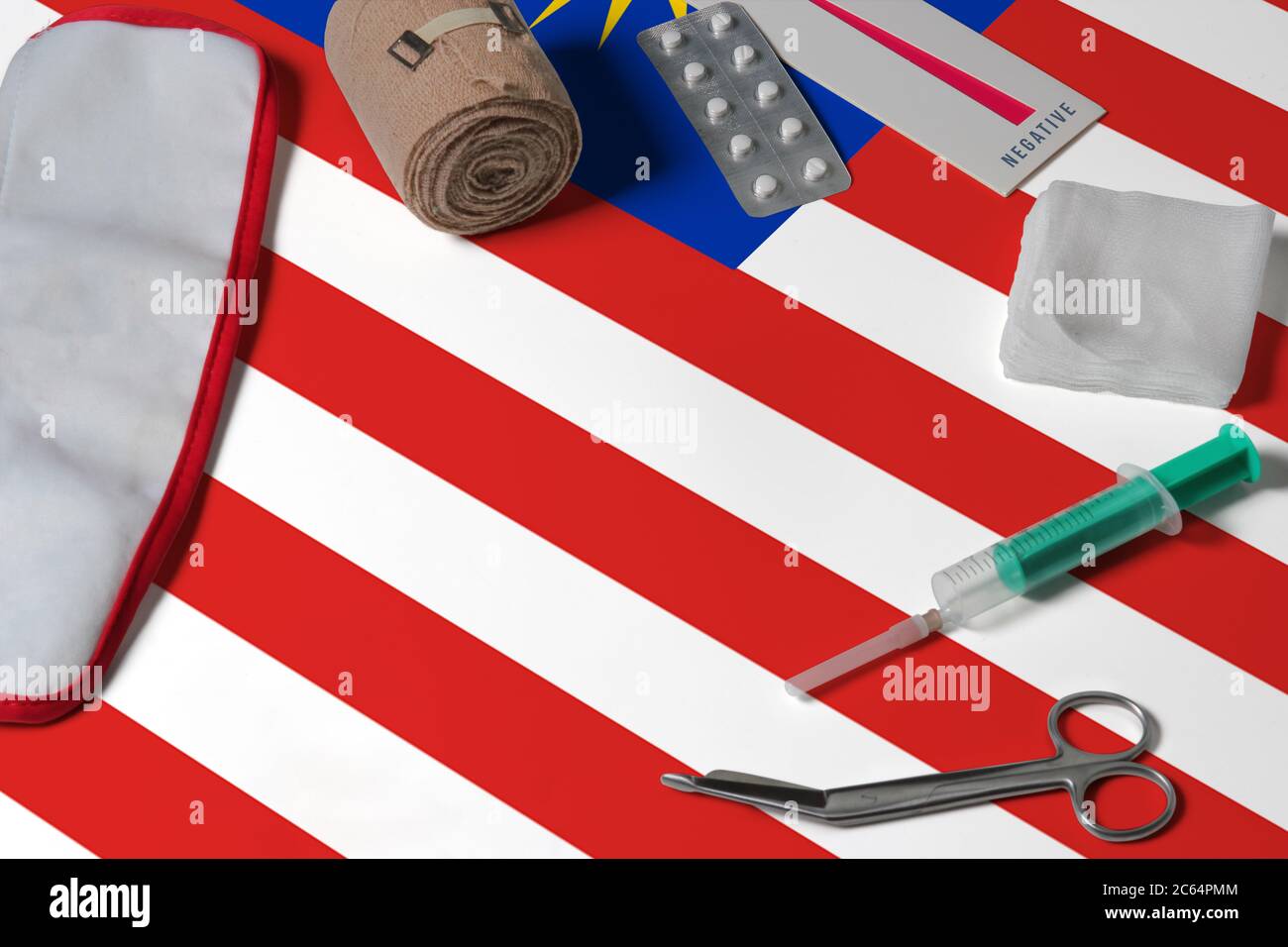 Malaysia flag with first aid medical kit on wooden table background ...