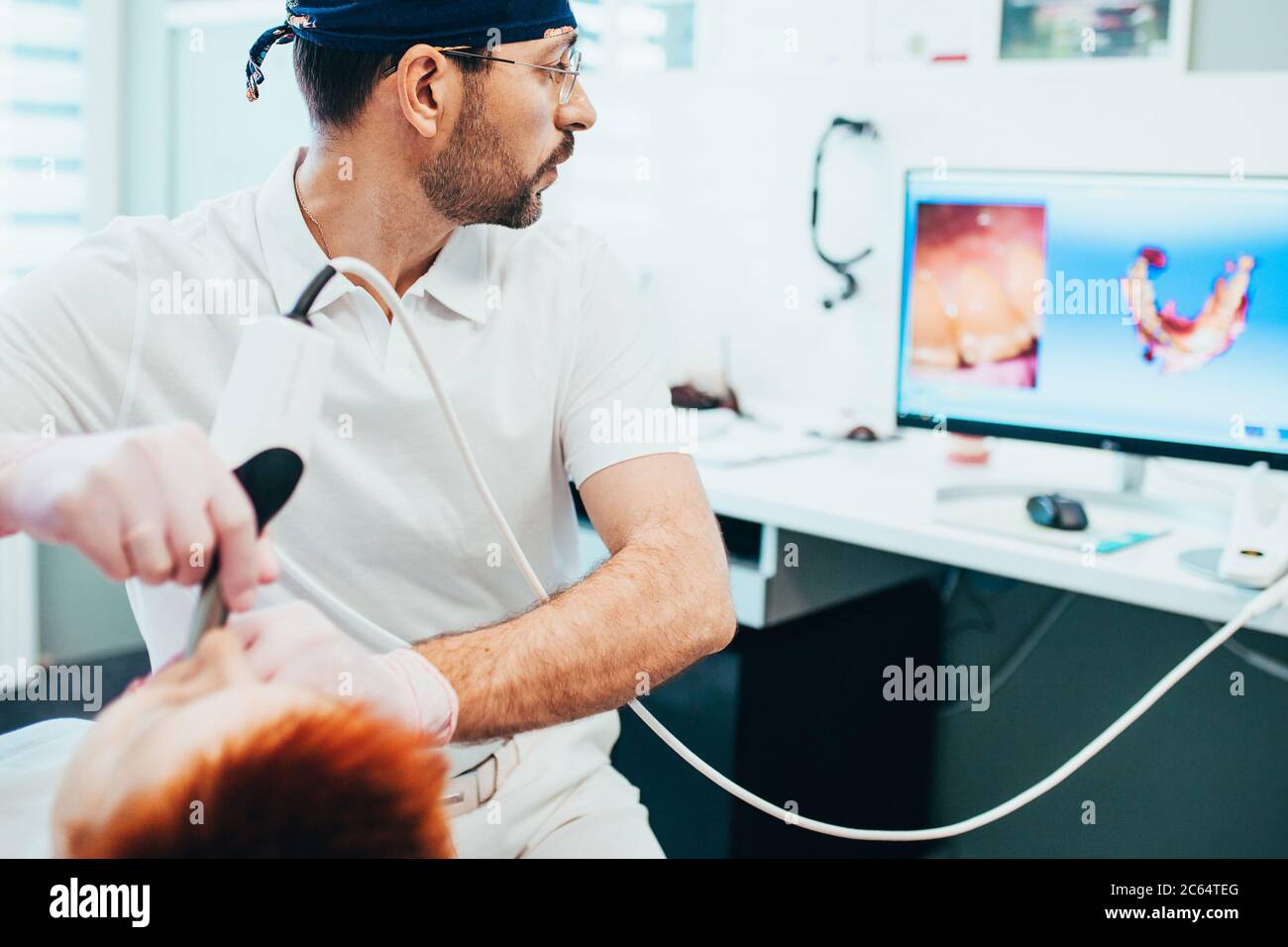 The doctor orthodontist scans the patient oral cavity and controls the ...