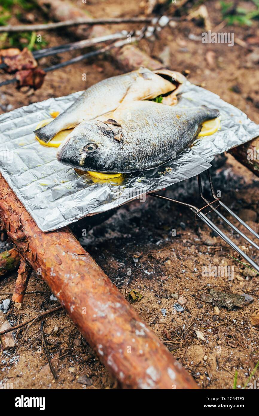 Roasting dorado fish with lemon over an open fire - vegetarian dish ...