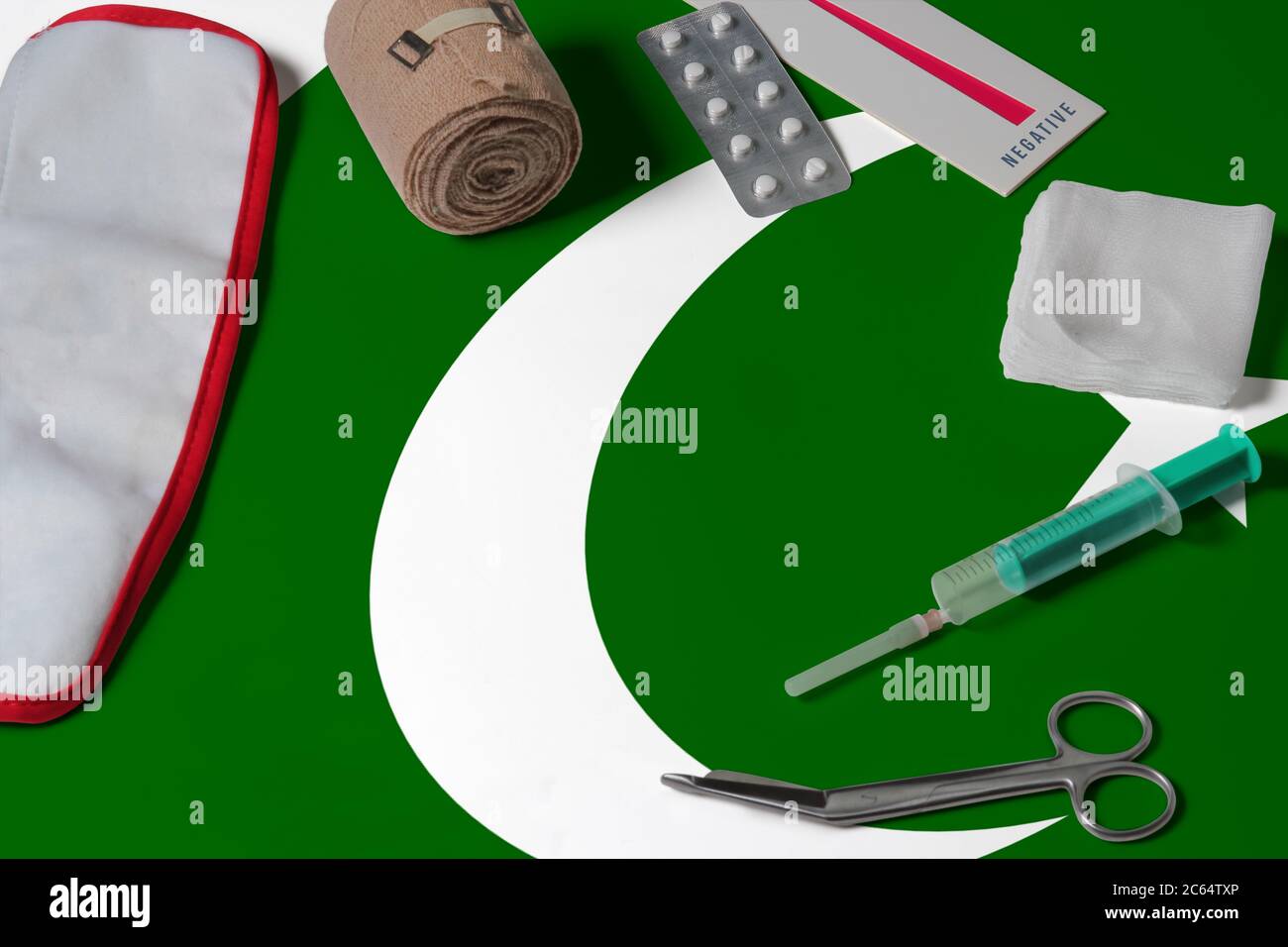 Pakistan flag with first aid medical kit on wooden table background ...