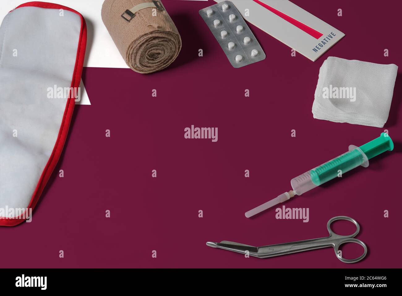 Qatar flag with first aid medical kit on wooden table background ...
