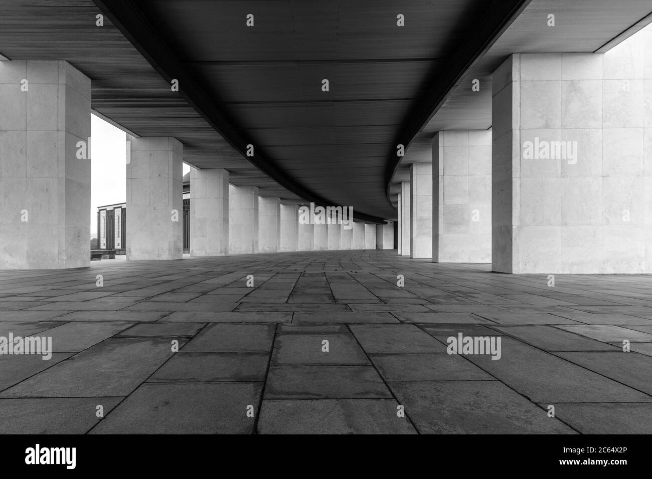 A smoothly curved gallery with rectangular vertical light columns of ...